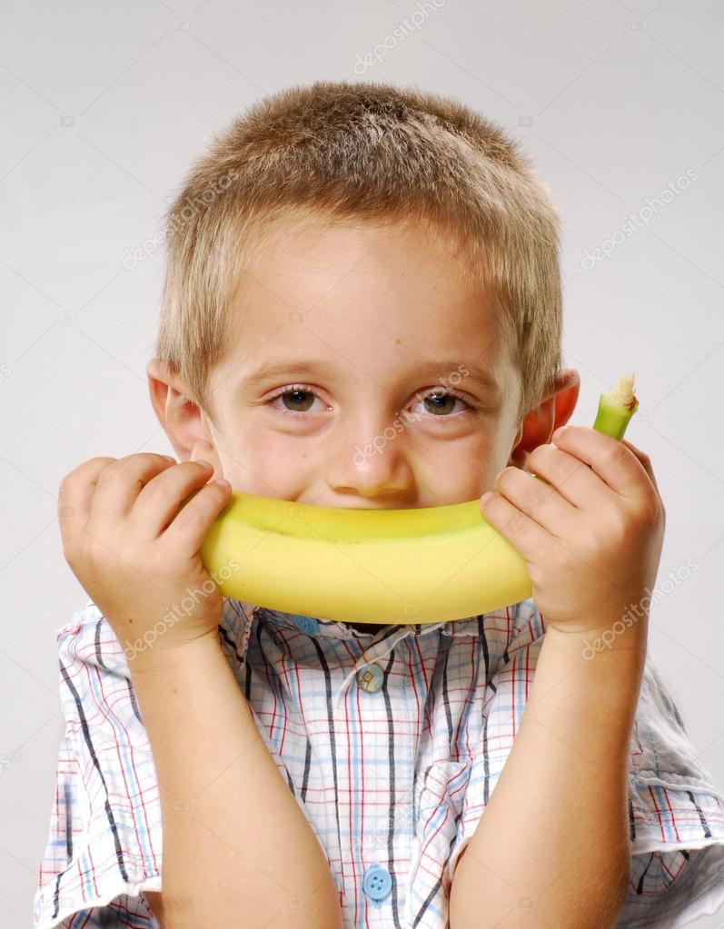 One little kid holding a banana.Kid eating banana. Stock Photo by ...