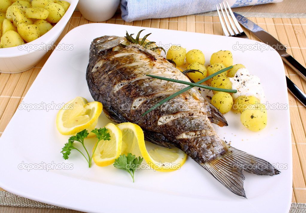 Poisson grillé avec pommes de terre, sauce et citron — Photographie ...