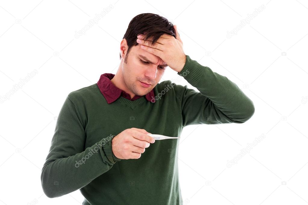 Young man suffering from a cold and checking his temperature on Stock ...
