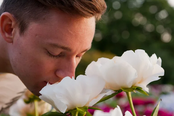 Man smells flowers - Stock Image - Everypixel