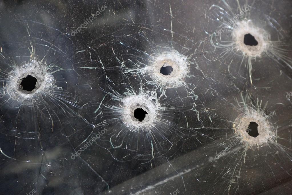 Multiple Bullet Holes In Glass