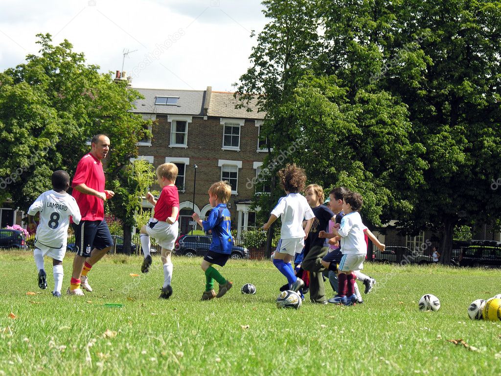Niños jugando al fútbol en el parque — Foto editorial de stock ...