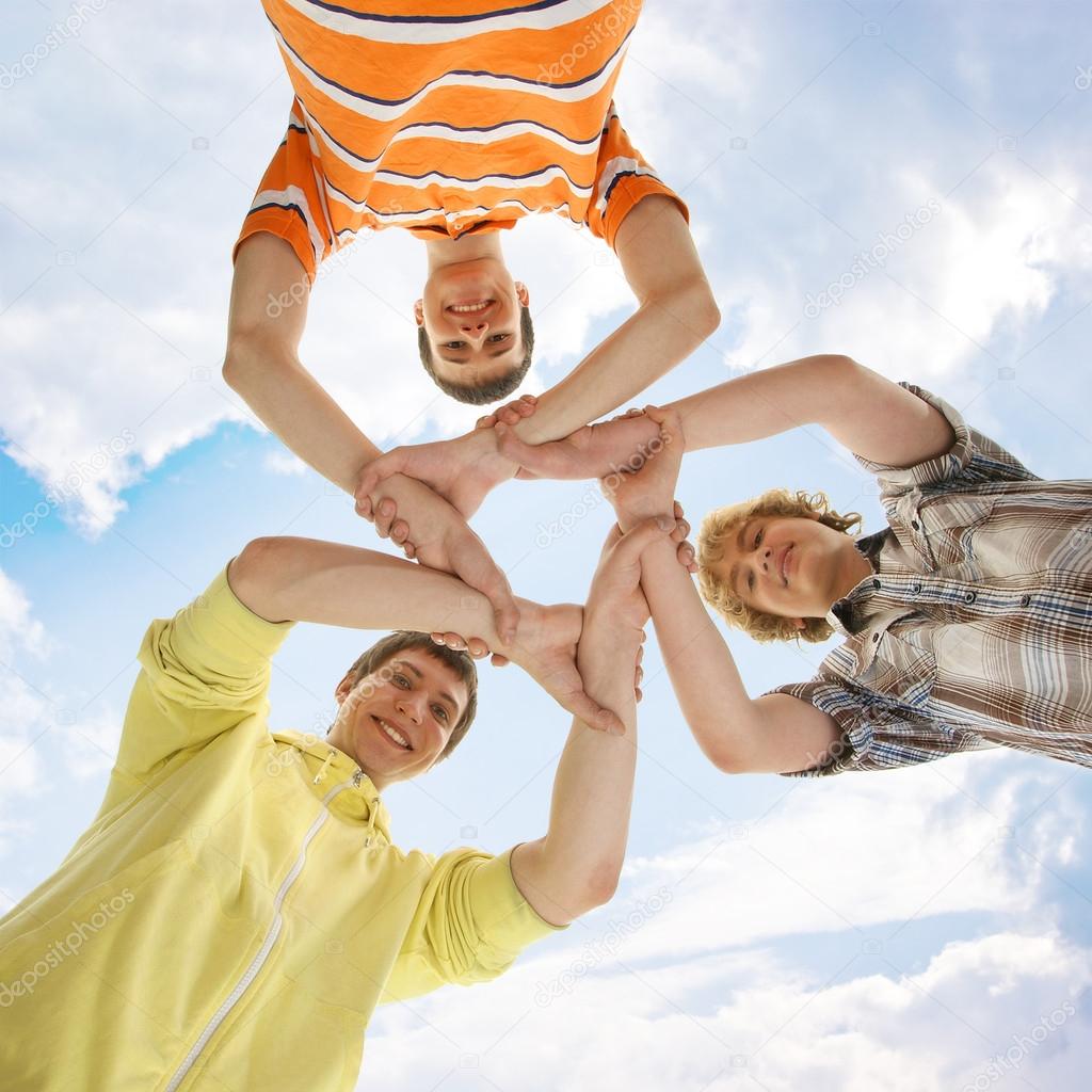 Large group of smiling friends staying together and looking at camera ...