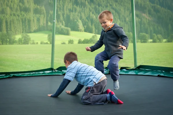 Young brothers jumping in mountain scenery. - Stock Image - Everypixel