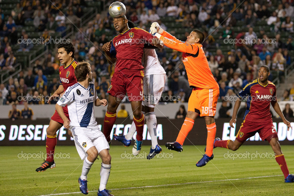 Jamison Olave gets a head on a corner kick while Nick Rimando tries to ...