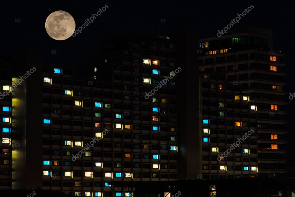 Full moon over colorful windows of residential house Stock Photo by ...