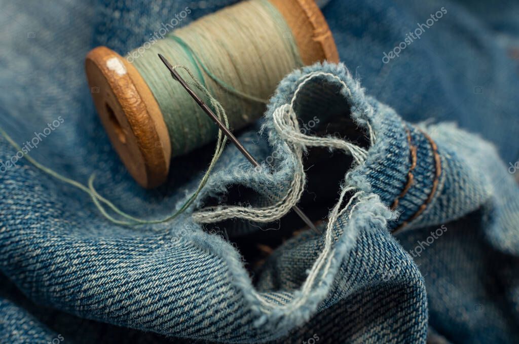 Agujero en jeans. Aguja con hilo para zurcir jeans. Herramientas para ...
