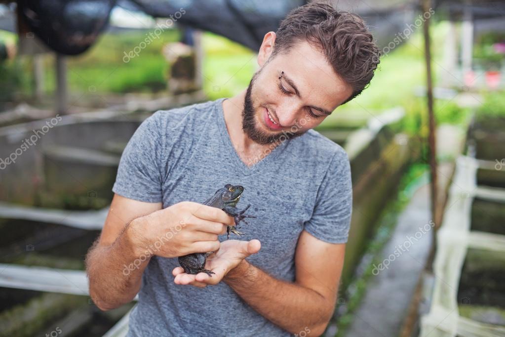 Man holding big black frog in hands — Stock Photo © apid #50783671