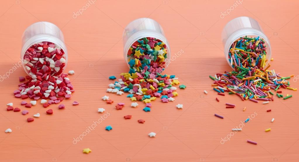 Colorful sugar sprinkles scattered on a wooden table — Stock Photo ...