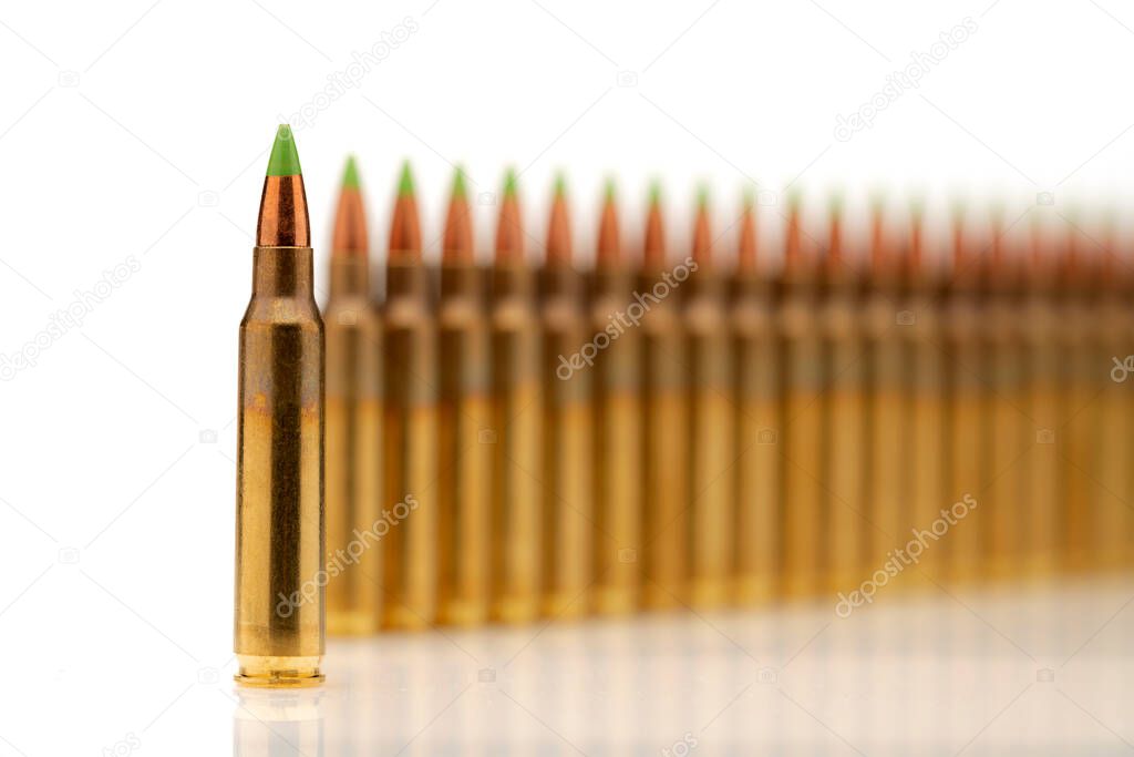 Un grupo de calibar 5.56, balas de punta verde ordenadas en la línea ...