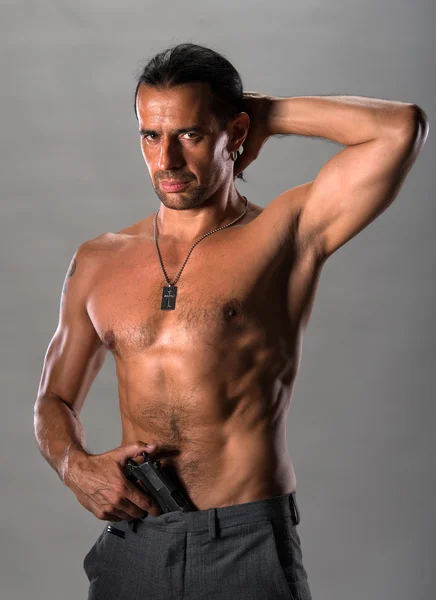 Handsome man in cap with a gun — Stock Photo © VBaleha #31502593