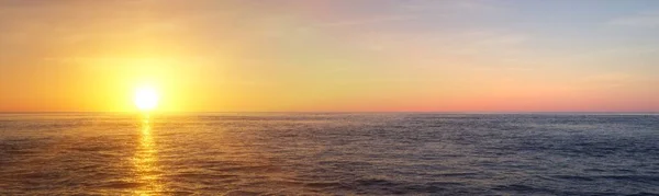 Wide panorama view of sunset or sunrise of open ocean or sea with blue ...