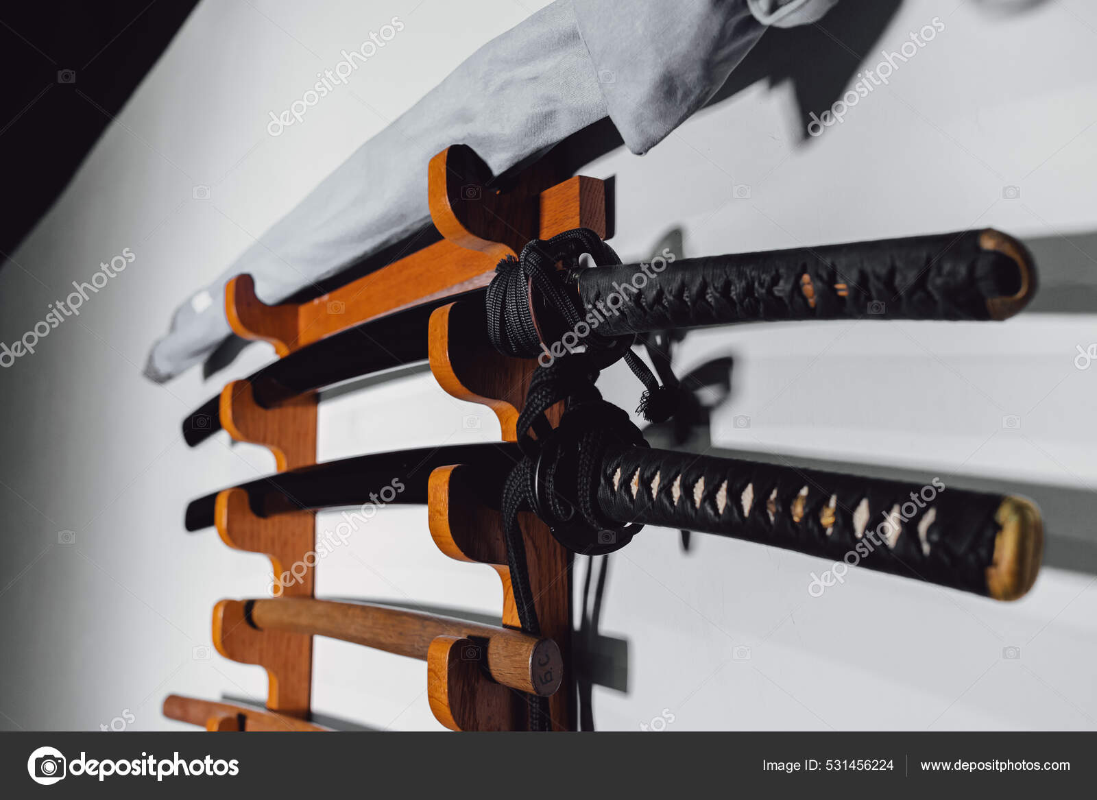 Special stand on the white wall for training swords made of oak wood ...