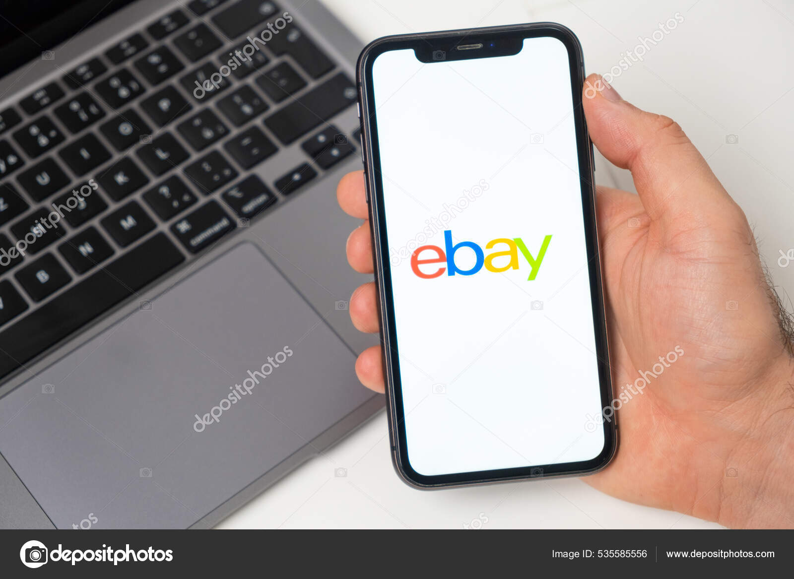Ebay the application is open in the smartphone. The man is holding a ...