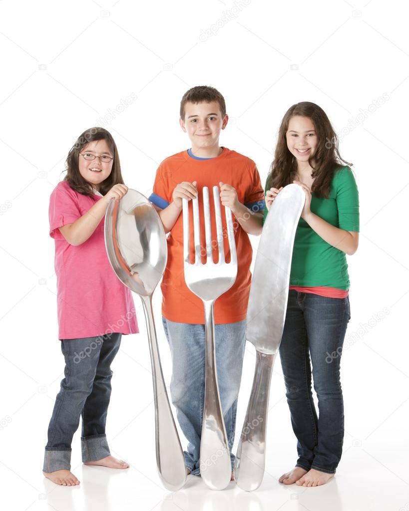 Healthy Eating. Diverse group of teenagers holding oversized utensils a ...