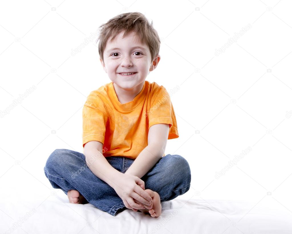 Smiling caucasian little boy sitting cross legged Stock Photo by ...