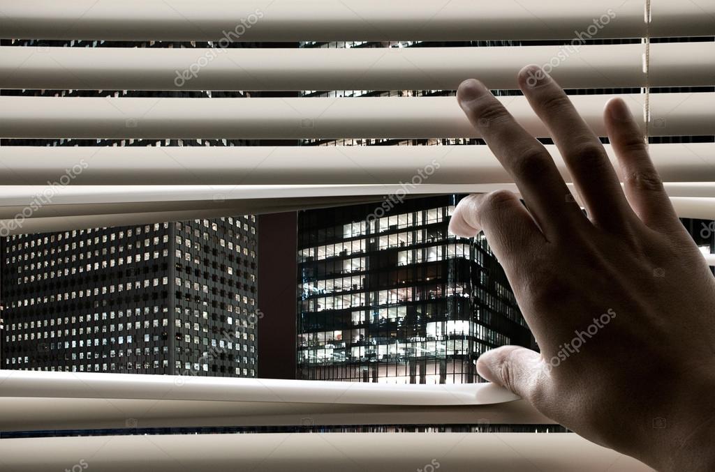 Man at office opening window blinds and seeing business towers Stock ...