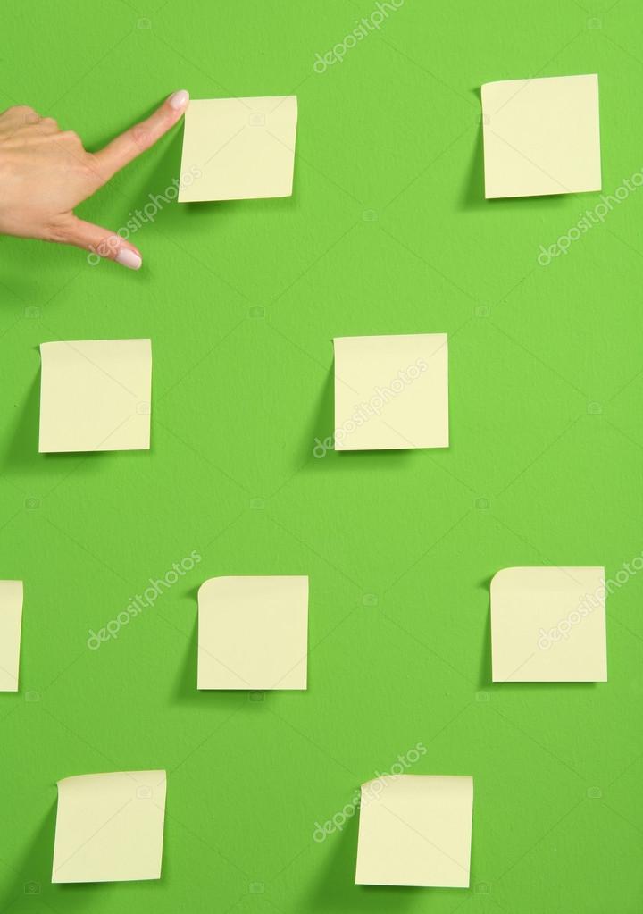 Hand on green wall with paper notes Stock Photo by ©Zveiger 32051879