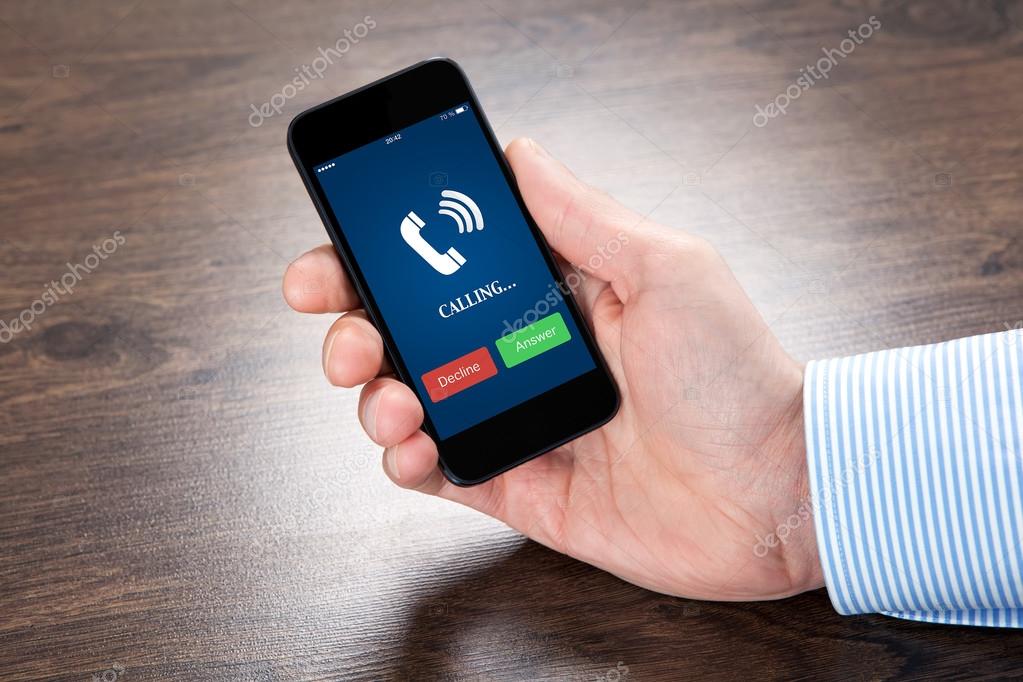 Businessman holding a phone with blue screen and the phone ringi ...