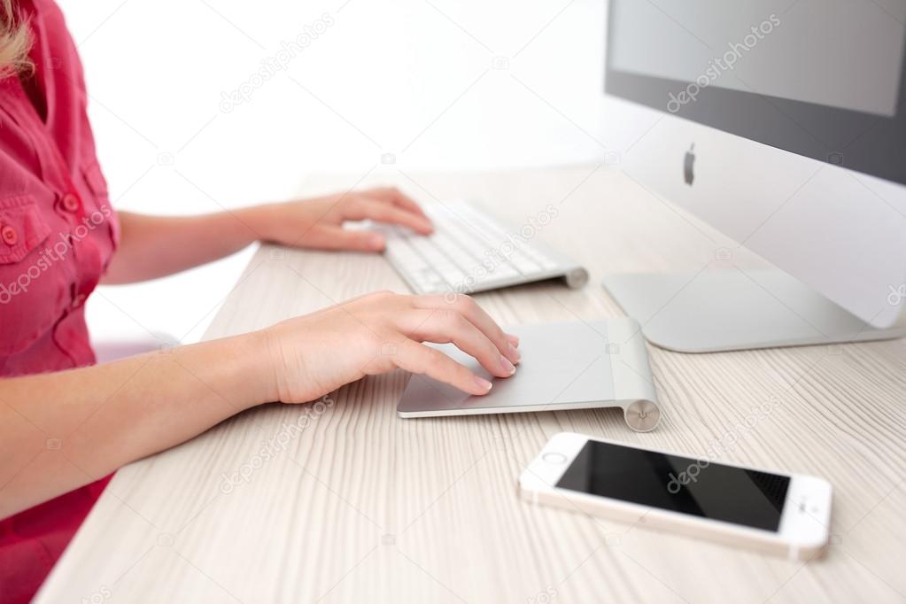 Woman sitting at a computer iMac and typing on the keyboard — Stock ...
