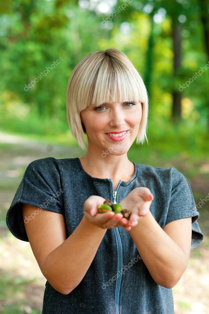 Attractive woman holding acorns outside — Stock Photo © bertys30 #32042379