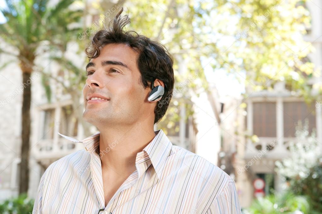 Businessman using a hands free device to have a conversation on his ...
