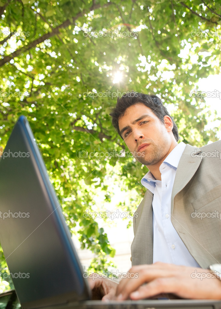 Attractive young businessman using a laptop pc computer Stock Photo by ...