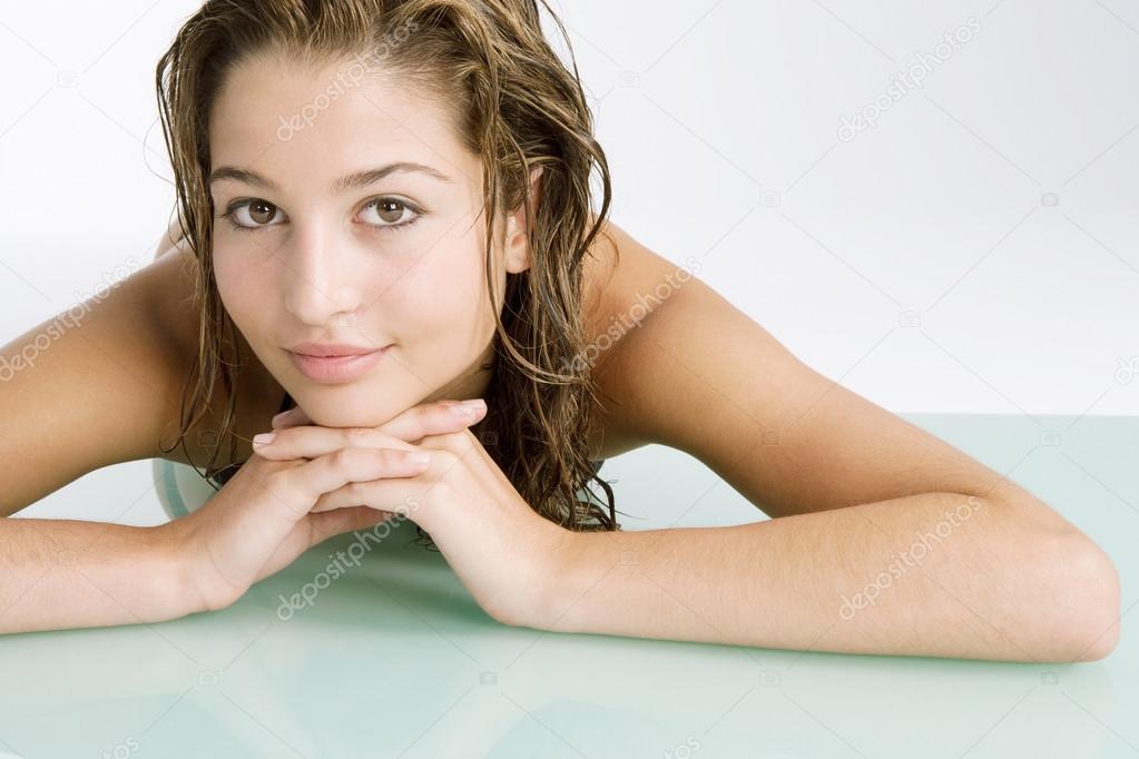 Young Woman Resting Her Head On Her Hands While Laying Down — Stock