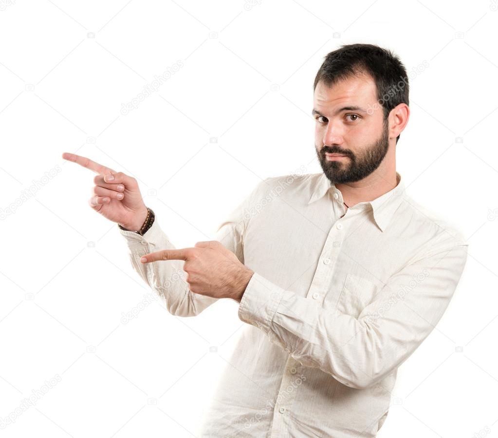 Joven apuntando a su derecha sobre fondo blanco — Foto de stock #37036469 © luismolinero