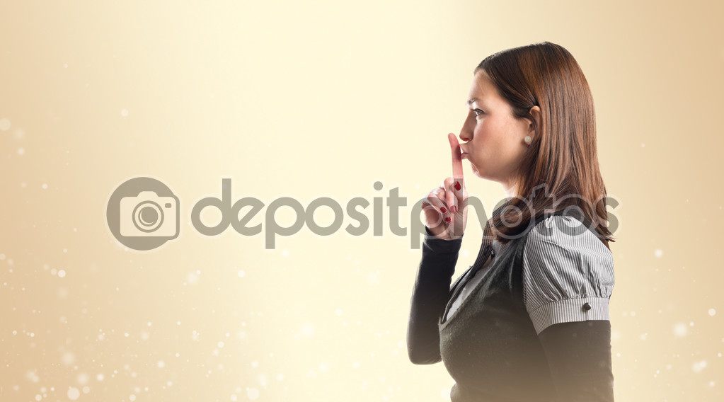 Young girl making silence gesture over isolated ocher background Stock ...