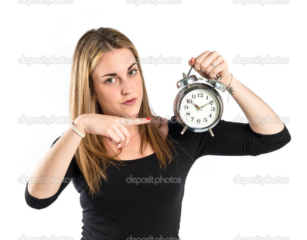 Happy blondr girl holding a clock over white background — Stock Photo ...