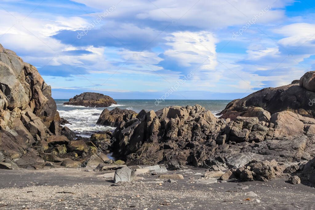 Surf en una playa rocosa con arena negra en Islandia 2022