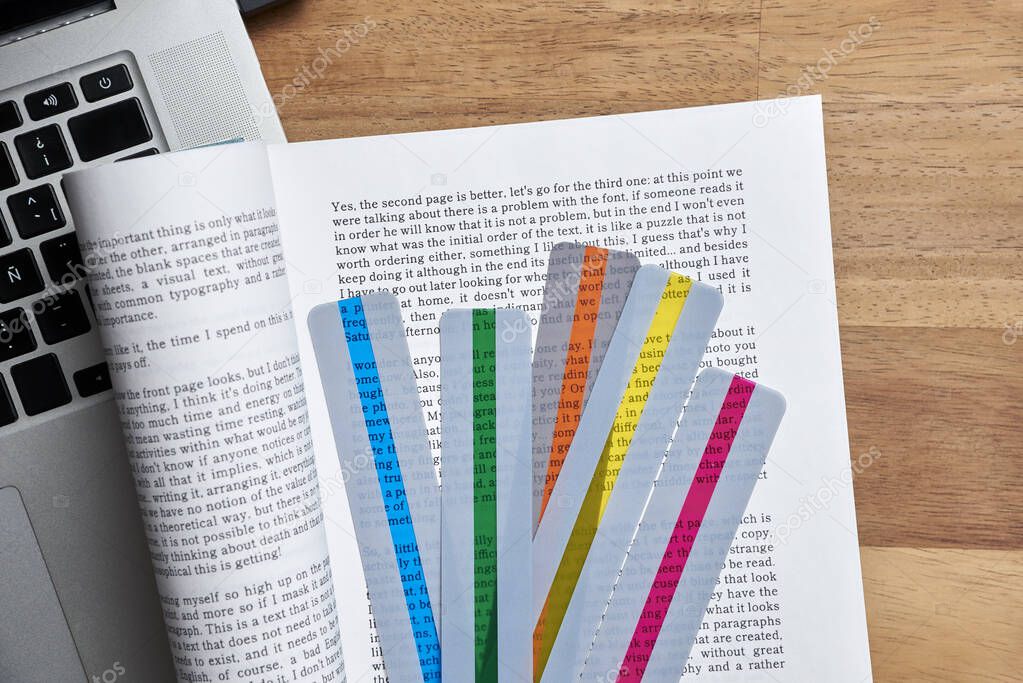 Pack of different colors reading rulers over an open book, coloured ...