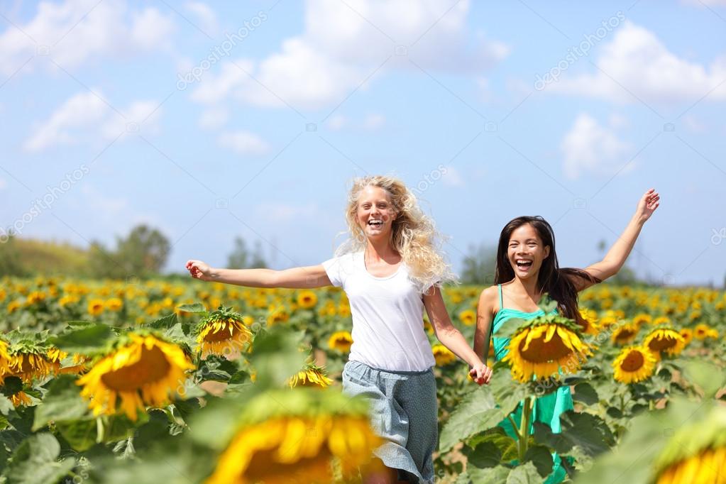 Two young women running through sunflowers — Stock Photo © Maridav ...
