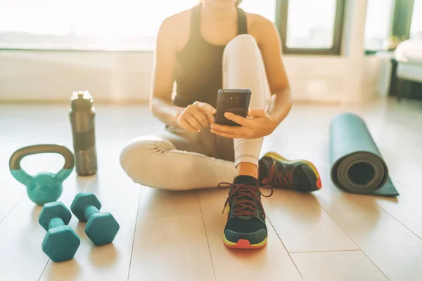 Fitness app on mobile phone for exercise at home. Woman using tech ...