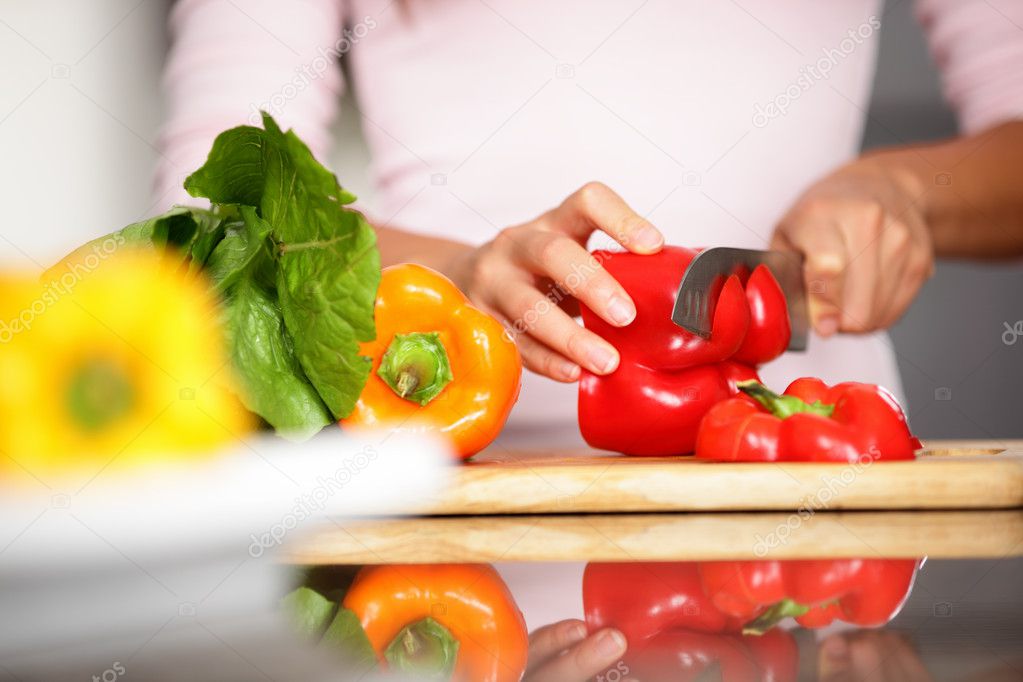 Peppers - woman cutting red pepper Stock Photo by ©Ariwasabi 21562291