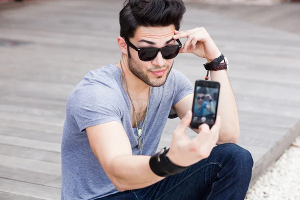 Attractive male model taking photos with a black smartphone — Stock ...