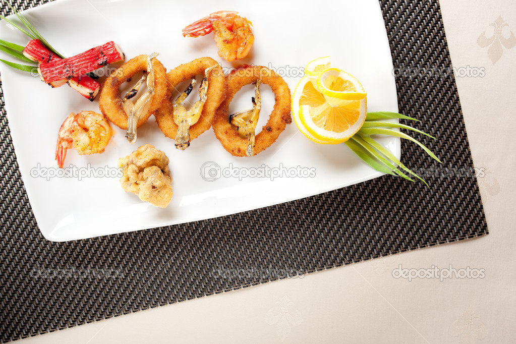 deliciosas patas de rana frita con aros de cebolla y limón en el plato 2024