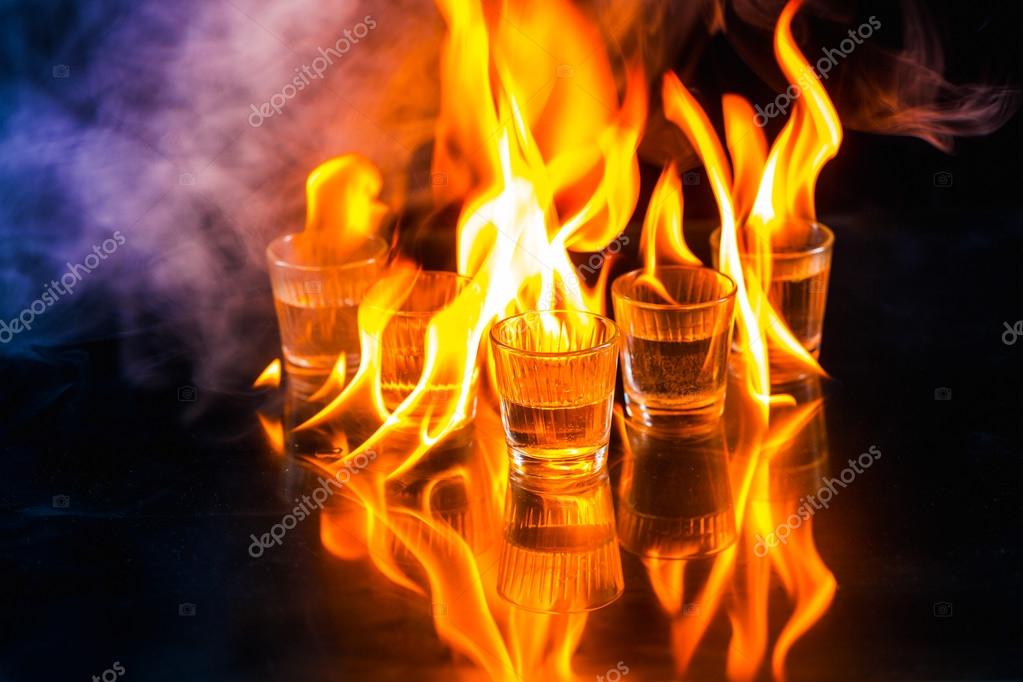 Glasses with burning alcohol on black background Stock Photo by ...
