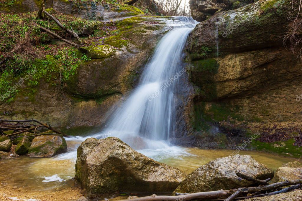 Un río de montaña en un canal natural con rápidos y cascadas en un parque natural a finales de ...