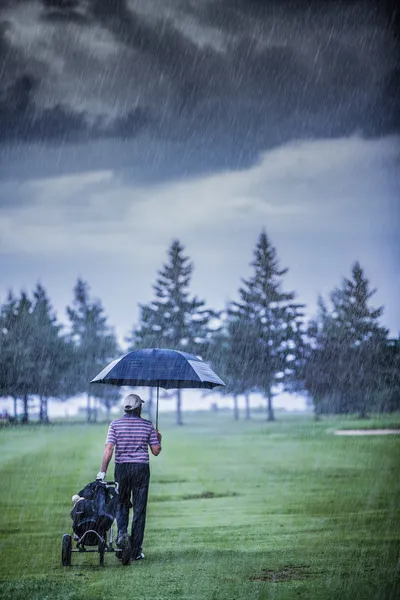 Golfer on a Rainy Day Leaving the Golf Course - Stock Image - Everypixel