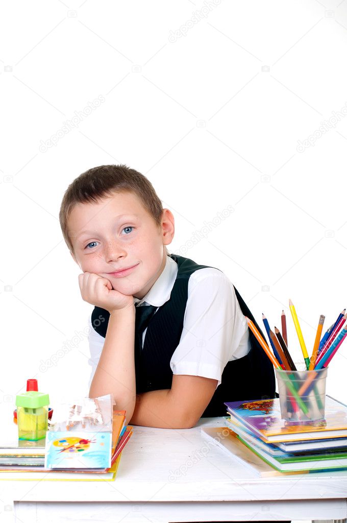 Little boy at his desk with an album for drawing, pencils and books on ...