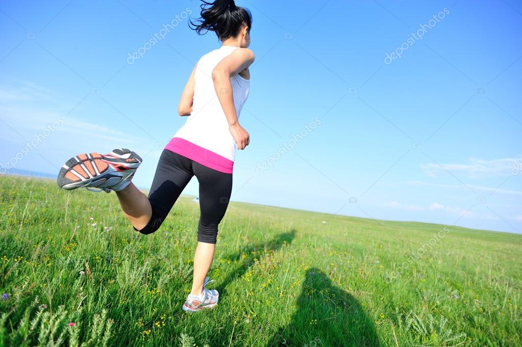 Runner athlete running on grass seaside. Stock Photo by ©lzf 51400341
