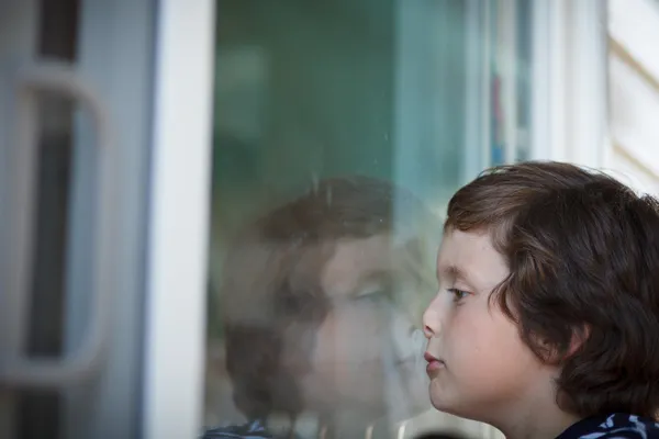 Boy looking through the window — Stock Photo © Dubova #61544709