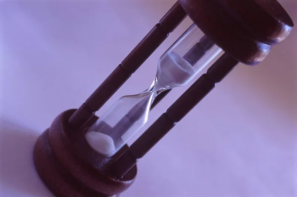 Hour glass or egg timer with sand falling between two glass bulbs to ...