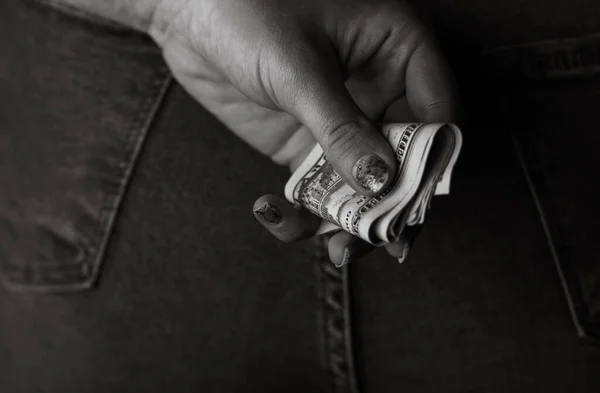 Woman hand taking money from jeans back pocket. Woman hiding money ...