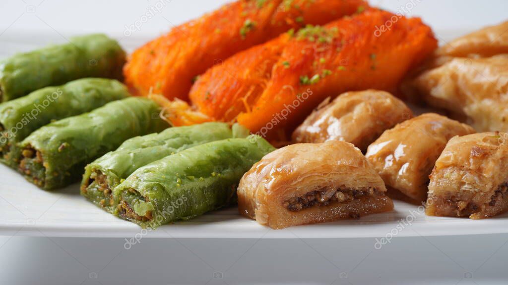 Una bandeja de pasteles turcos que incluye baklava, knafeh, un pastel ...