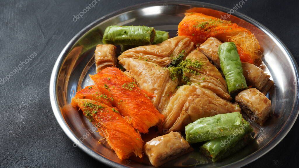Una bandeja de pasteles turcos que incluye baklava, knafeh, un pastel ...