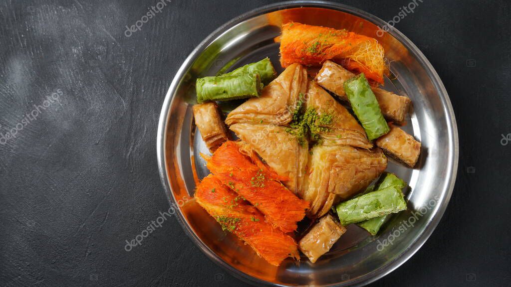 Una bandeja de pasteles turcos que incluye baklava, knafeh, un pastel ...