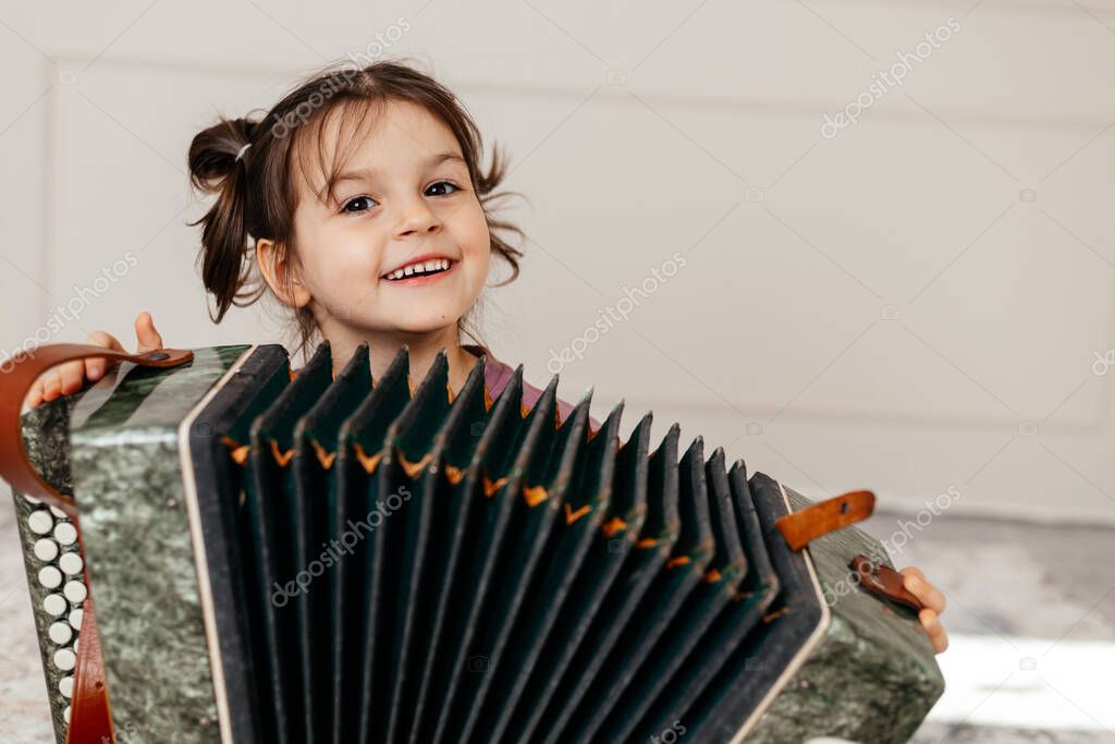 Un niño tocando el acordeón. Niña niño aprende a tocar armónico ...